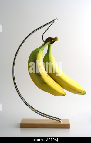 Three bananas on a curved banana stand Stock Photo - Alamy