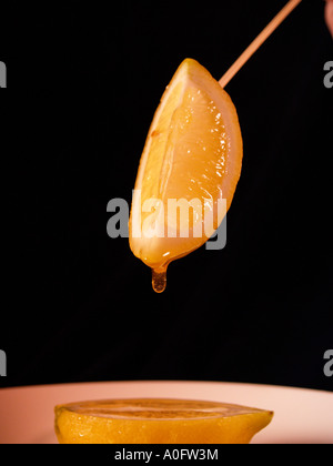 lemon with honey on a black ground Stock Photo - Alamy
