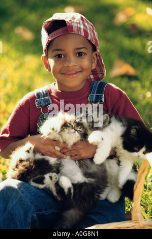Portrait of a boy holding cats Stock Photo - Alamy