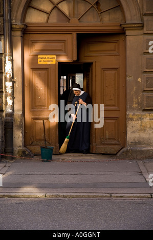 Catholic nun with habit cleaning the outside part of a convent in the ...
