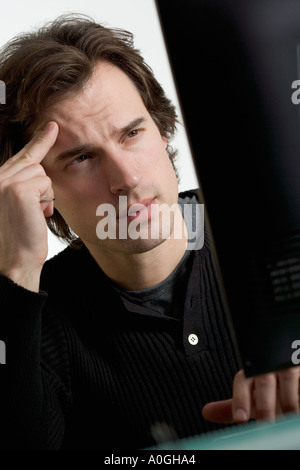 Confused masculine man posing with fingers crossed for good luck ...
