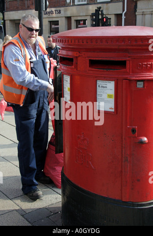 postman collecting letters from red Postbox. Poole UK Stock Photo - Alamy