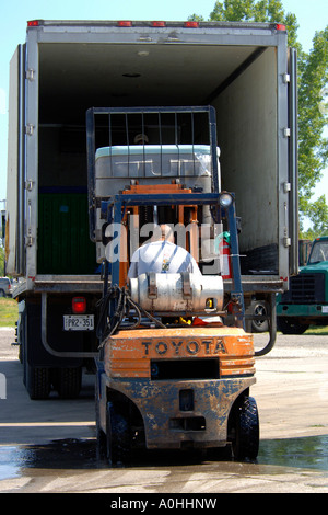 A Forklift truck moving cargo around a factory loading bay in Stock ...