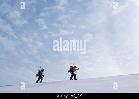 Snowboarders trudging through snow Stock Photo - Alamy