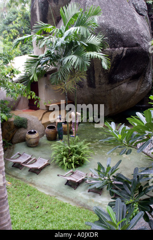 Two ladies in sarongs soak themselves using pots of water in the ...