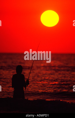 Fisherman on the beach at sunset Stock Photo - Alamy