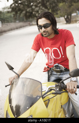 An indian young man riding a motorcycle near a paddy field Stock Photo ...