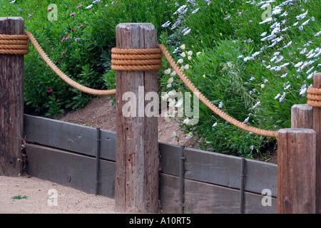 old rope wrapped around a pole that is surrounded by sand, beach Stock ...