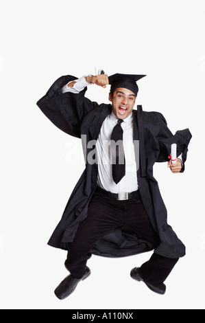 Male graduate student with diploma shouting into megaphone on yellow ...