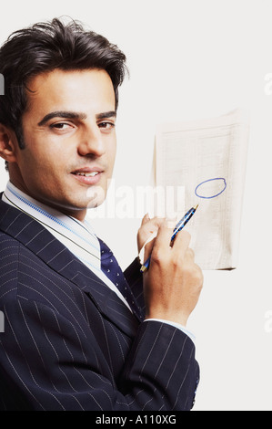 Business man marking on data sheet using metal pen Stock Photo - Alamy