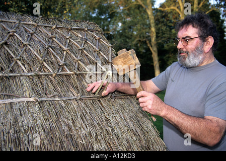 Making the traditional thatching spars from split hazel wood Stock ...