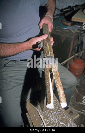 Making the traditional thatching spars from split hazel wood Stock ...