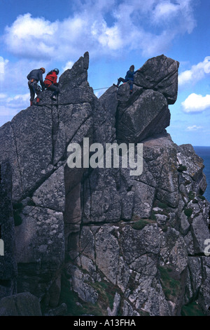 Climbers on [Commando Ridge] at Bosigran Cornwall England against dark ...