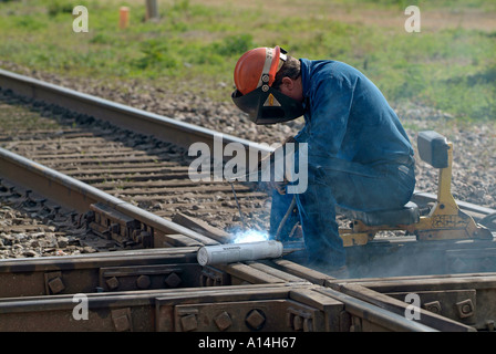 Welder performs repairs and maintenance on a section of a railroad ...