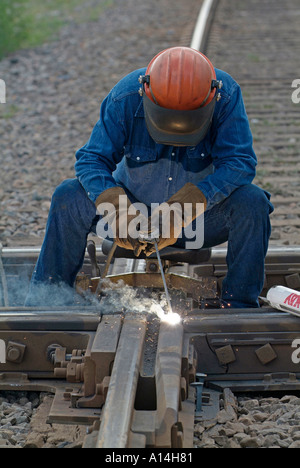 Welder performs repairs and maintenance on a section of a railroad ...