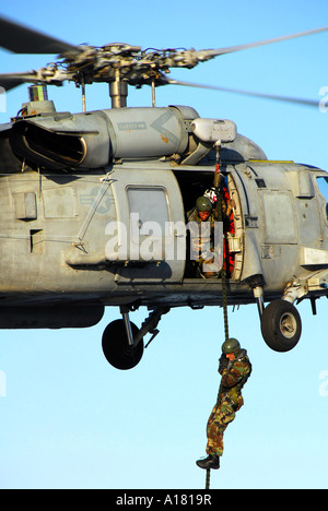 An explosive ordnance disposal technician fast ropes onto the flight ...