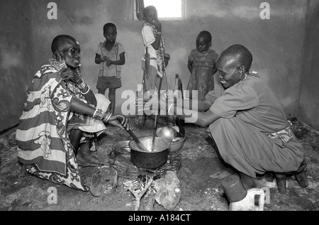 Maasai women cooking over a wood fire in their new concrete house, 2 ...