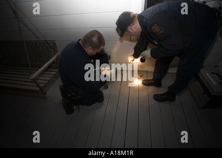 Crime Scene Technician and Detective inspects broken window at the ...