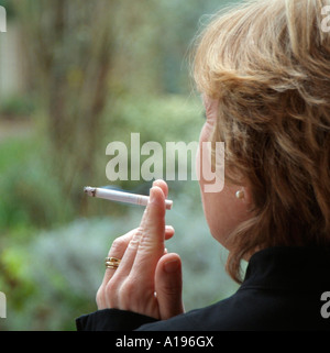 Smoking. Woman breathing out the smoke from a cigarette (not seen ...