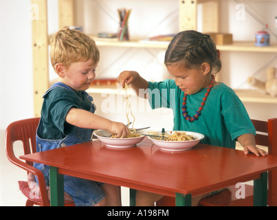 Boy and girl eating spaghetti together Stock Photo - Alamy