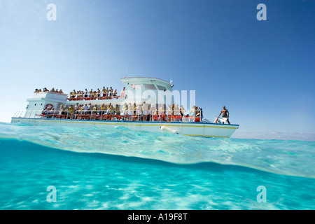Grand Cayman Sandbar under over Woman in yellow suit floats in clear ...