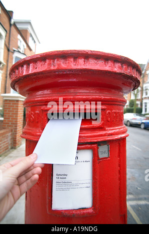 Posting a Letter Into a Post Box, UK Stock Photo - Alamy