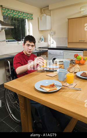 Young disabled man having breakfast Stock Photo - Alamy