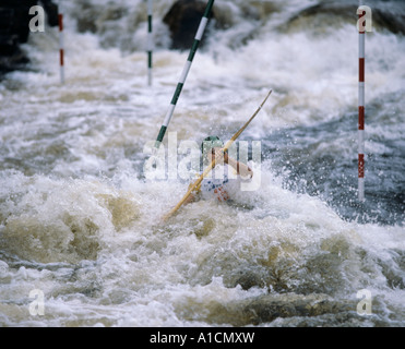 A person in a kayak navigating through the choppy waters of a river in ...