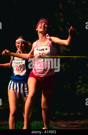 Female runner victorious at the finish line in a track race Stock Photo ...
