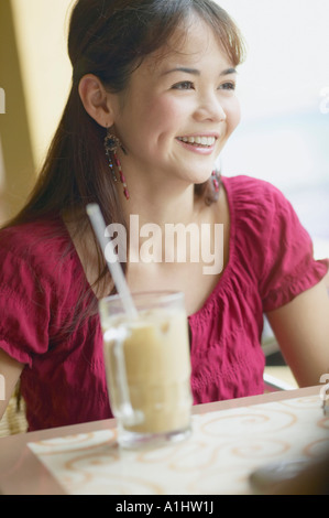 Young asia woman sitting alone and working on a laptop at coffee shop ...