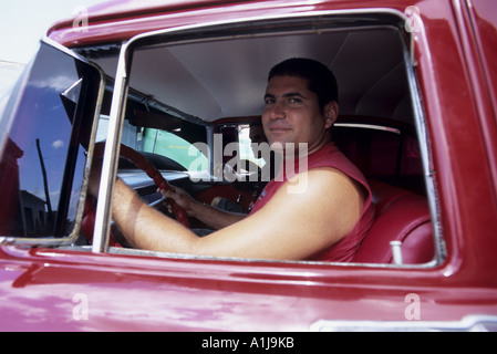 The proud owner in his beautifully kept up red American vintage car in ...
