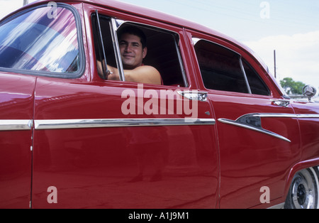 The proud owner in his beautifully kept up red American vintage car in ...