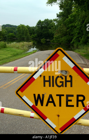 Road closed sign and high water flooding roadway. Storm and rain damage ...