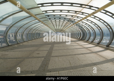 Pedestrian footbridge inside translucent steel framed tubular tunnel ...