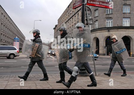 Riot police in full combat gear on standby in the town plaza during ...