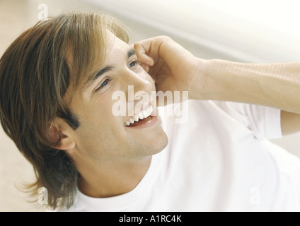 Slacker man talking on the phone while eating at work / modern office ...