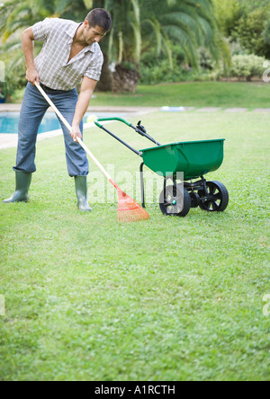 Man raking over grass Stock Photo - Alamy