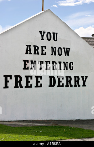 Sign entering Free Derry with mural by Bogside Artists on side of house ...