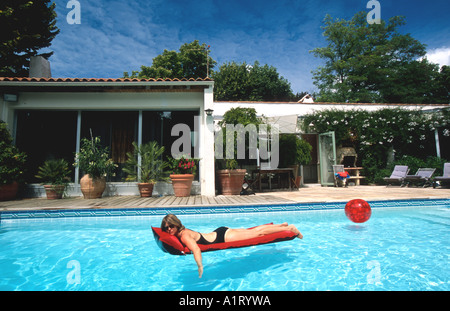Woman 30 40 yrs floating on inflatable airbed lilo in swimming pool ...