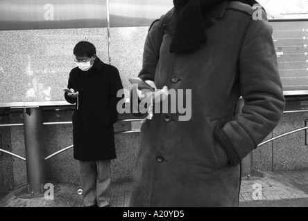 Japanese people using their telephones for text messaging, Shibuya ...