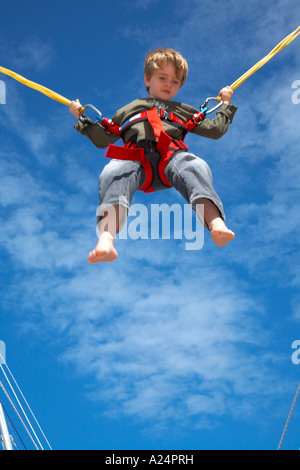 Bungee jump trampoline boy - an excited young boy practices bungee ...