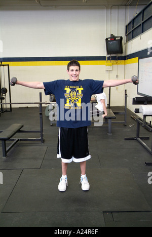 Students work out in a weight training room in a high school class ...