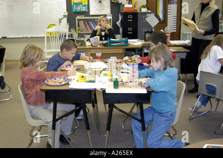 3rd grade elementary students working together in group helping each ...
