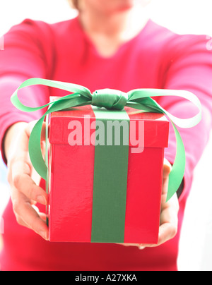 Hands holding wrapped Christmas gift over kraft paper with wide copy ...