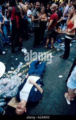 A drunk young man collapsed and sleeping on the street outside a bar in ...