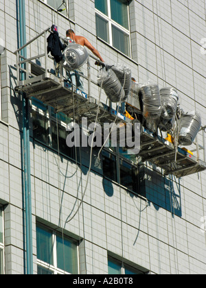 worker in a facade lift repair works on storefront facade of a multi ...