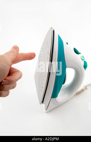 Hand touching steam iron Stock Photo - Alamy