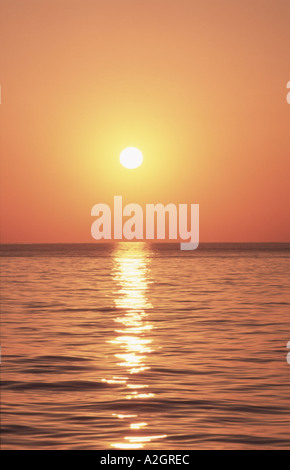 Sun reflecting in sea at sunset Stock Photo - Alamy