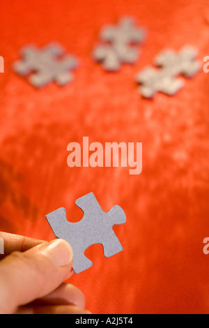 hand holding a missing piece in a tangram puzzle Stock Photo - Alamy