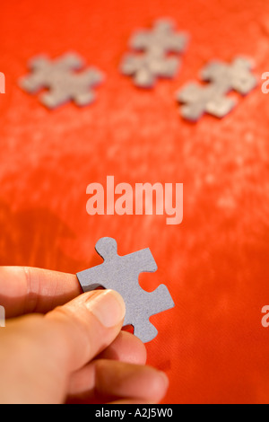 Hand holding a missing piece in a tangram puzzle Stock Photo - Alamy